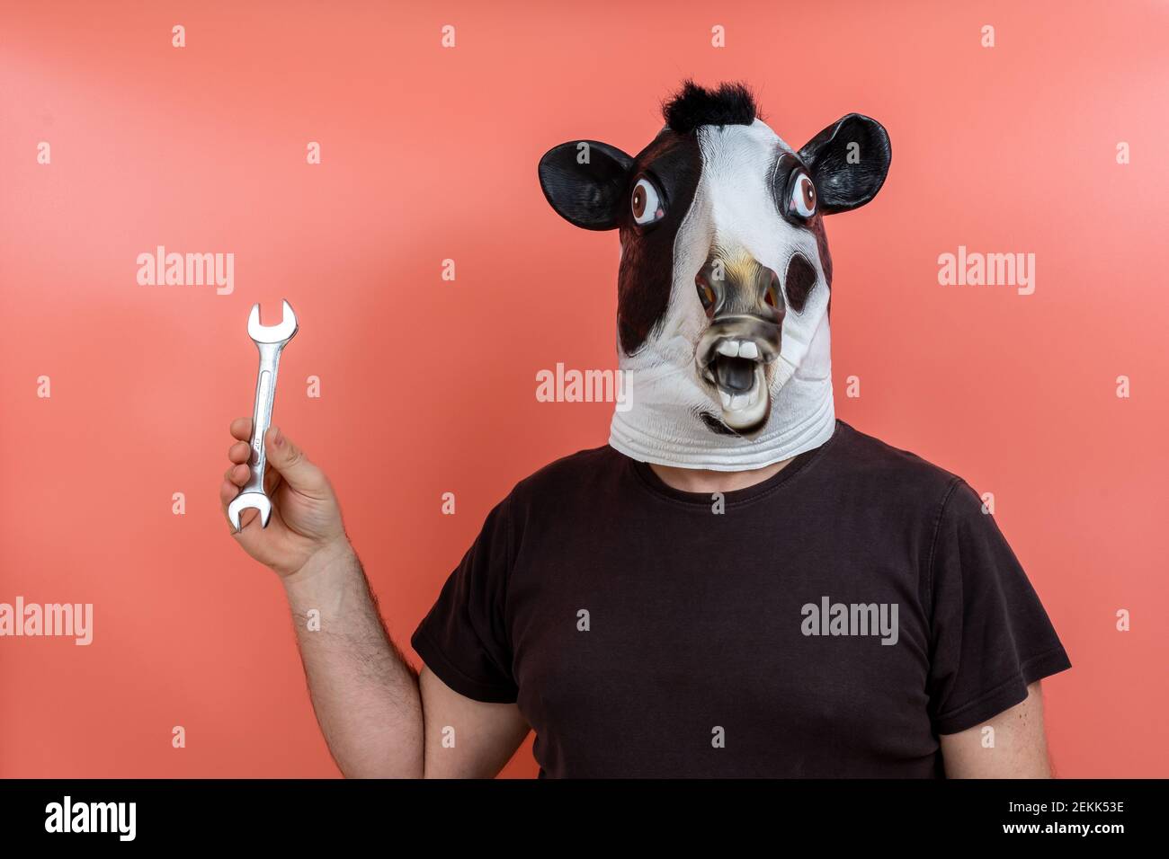 costumed person wearing a cow's head mask holding a mechanic's wrench ...