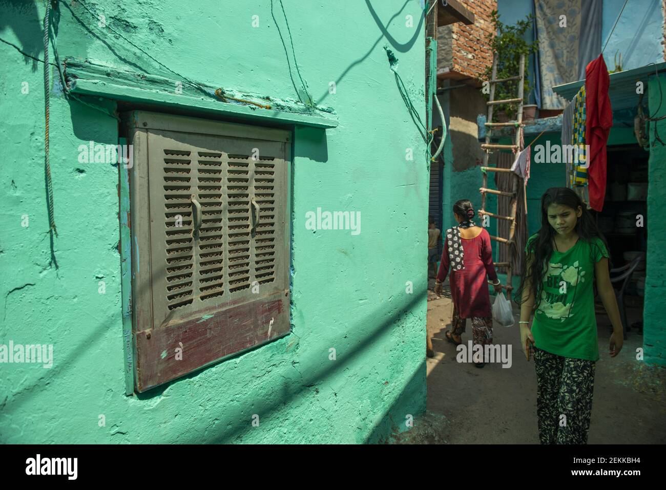 A woman passing by the narrow lane in the slum area. Anna Nagar Slum is ...