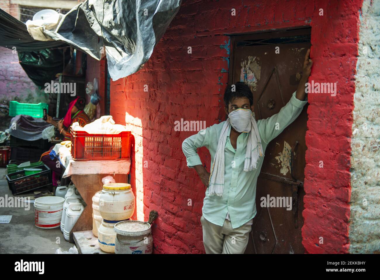 A slum-dweller with a covered face standing next the house. Anna Nagar ...