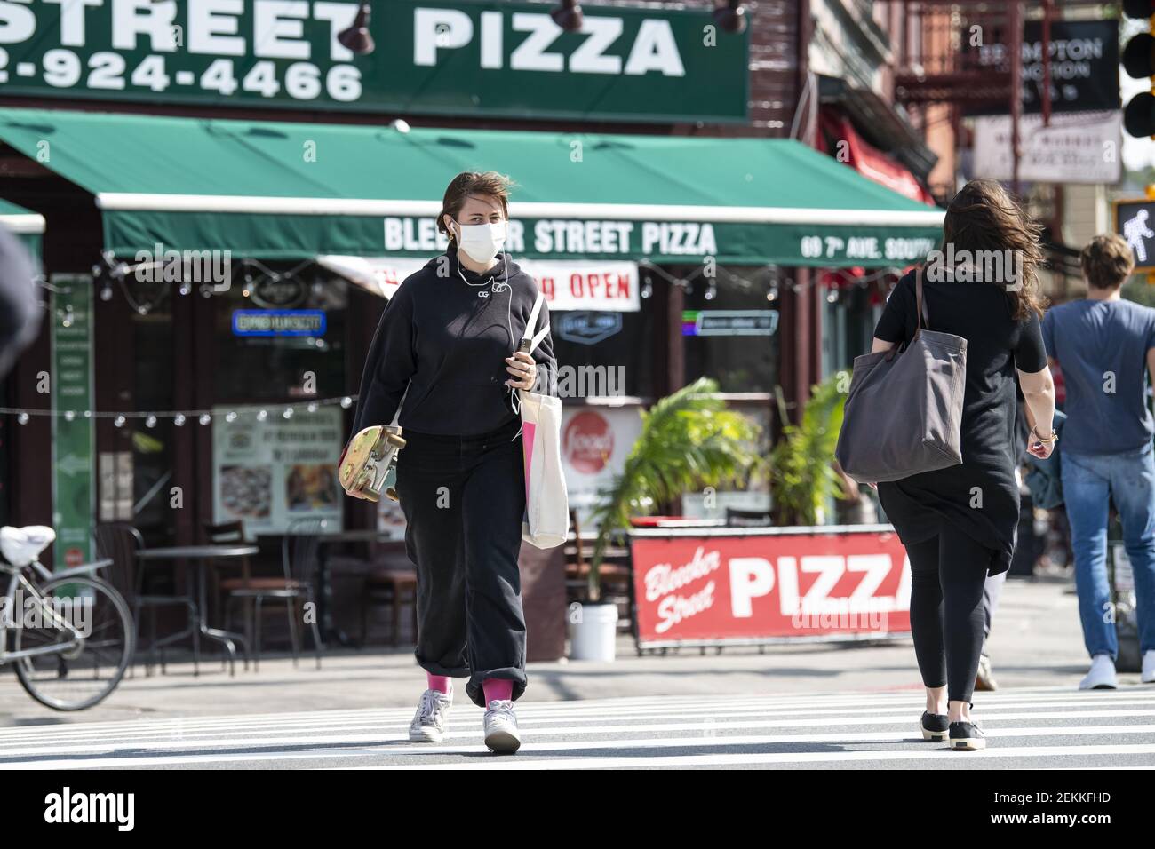 September 18, 2020: A woman wearing a face covering walks across the ...