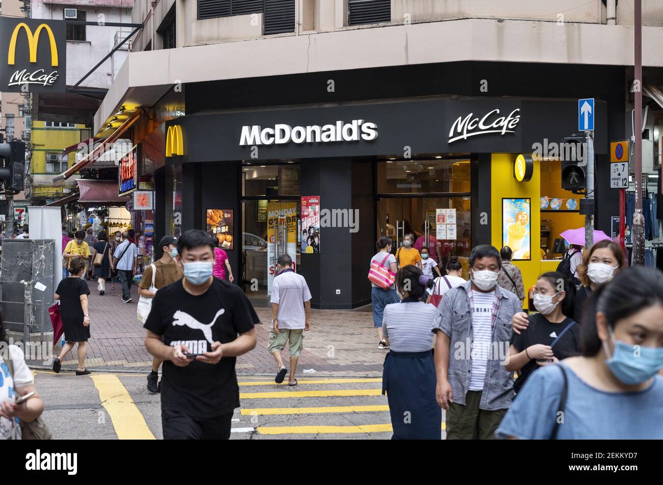 Pedestrians wearing face masks walk past the American multinational ...