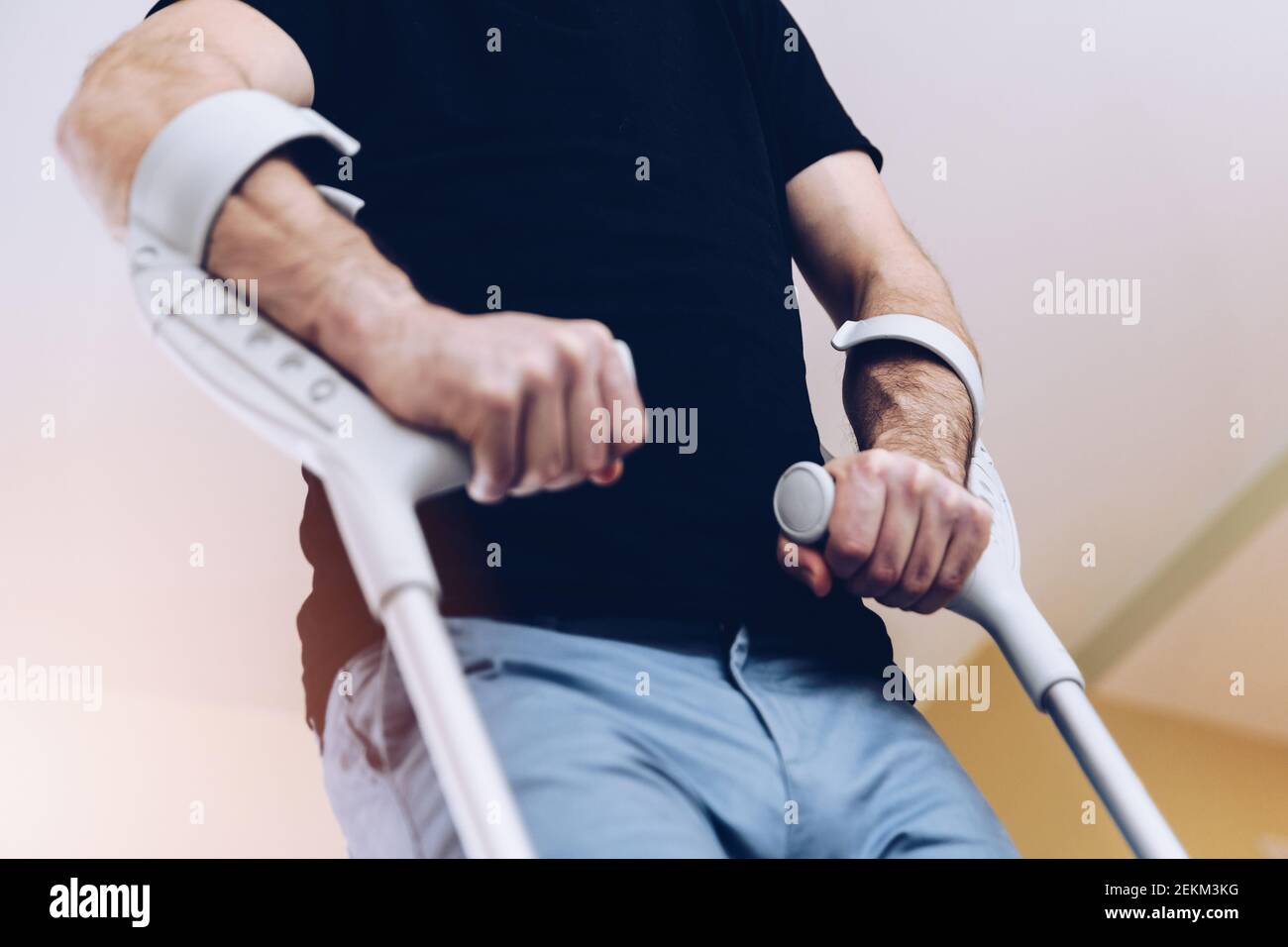 Disabled young man using crutches to walk Stock Photo - Alamy