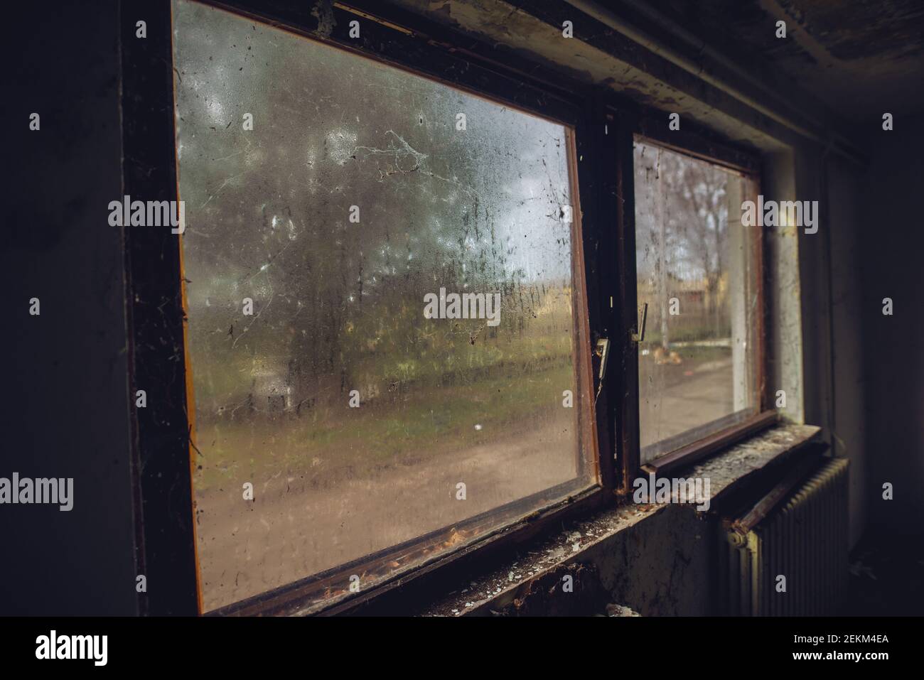 Close up focus view of ruined old forgotten cracked window with cobweb ...