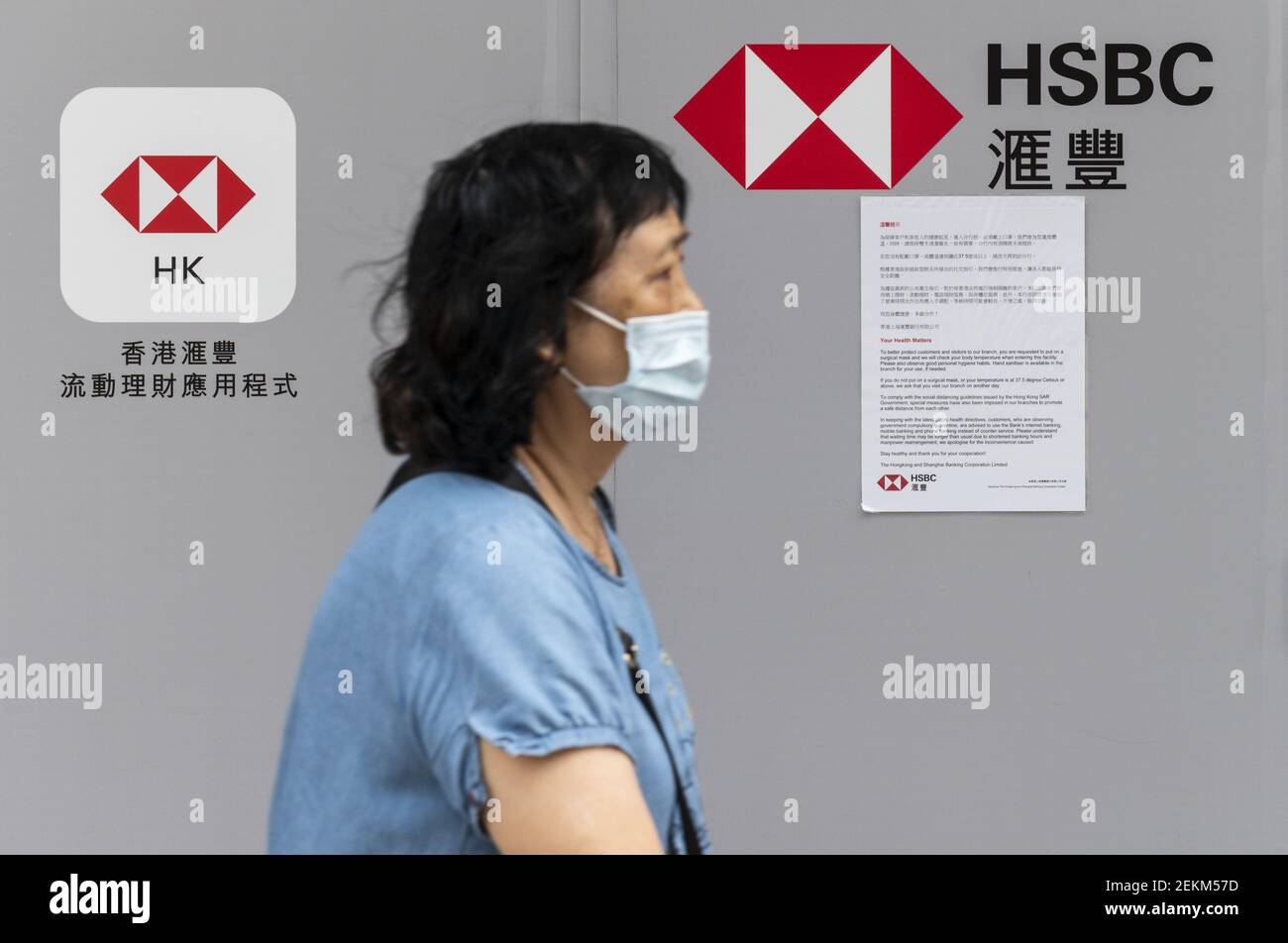 A pedestrian wearing a mask walks past the British multinational ...