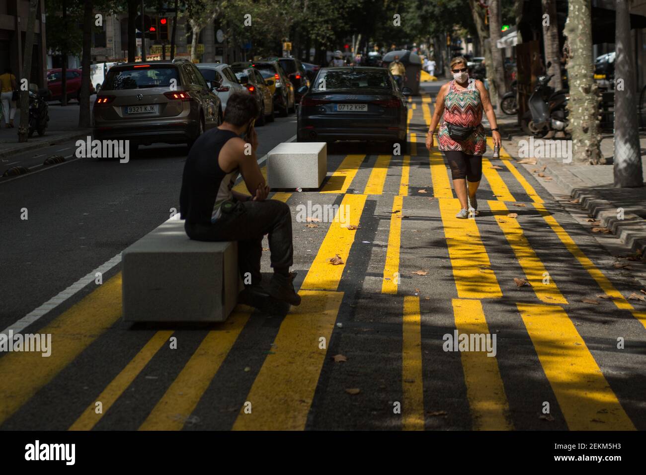 A woman wearing a face mask walking through the pedestrian area ...