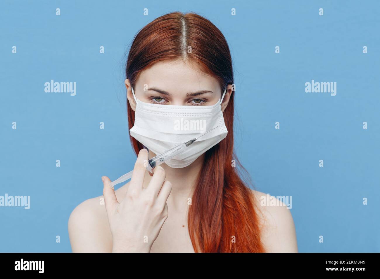emotional woman with syringe in hand and medical mask injection vaccine ...