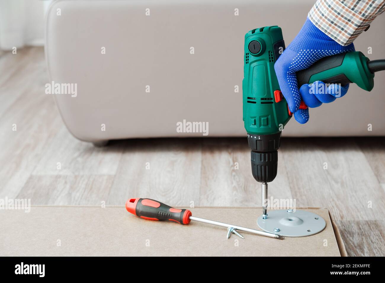Electric Drill works in handyman hands at home. Furniture assembly ...