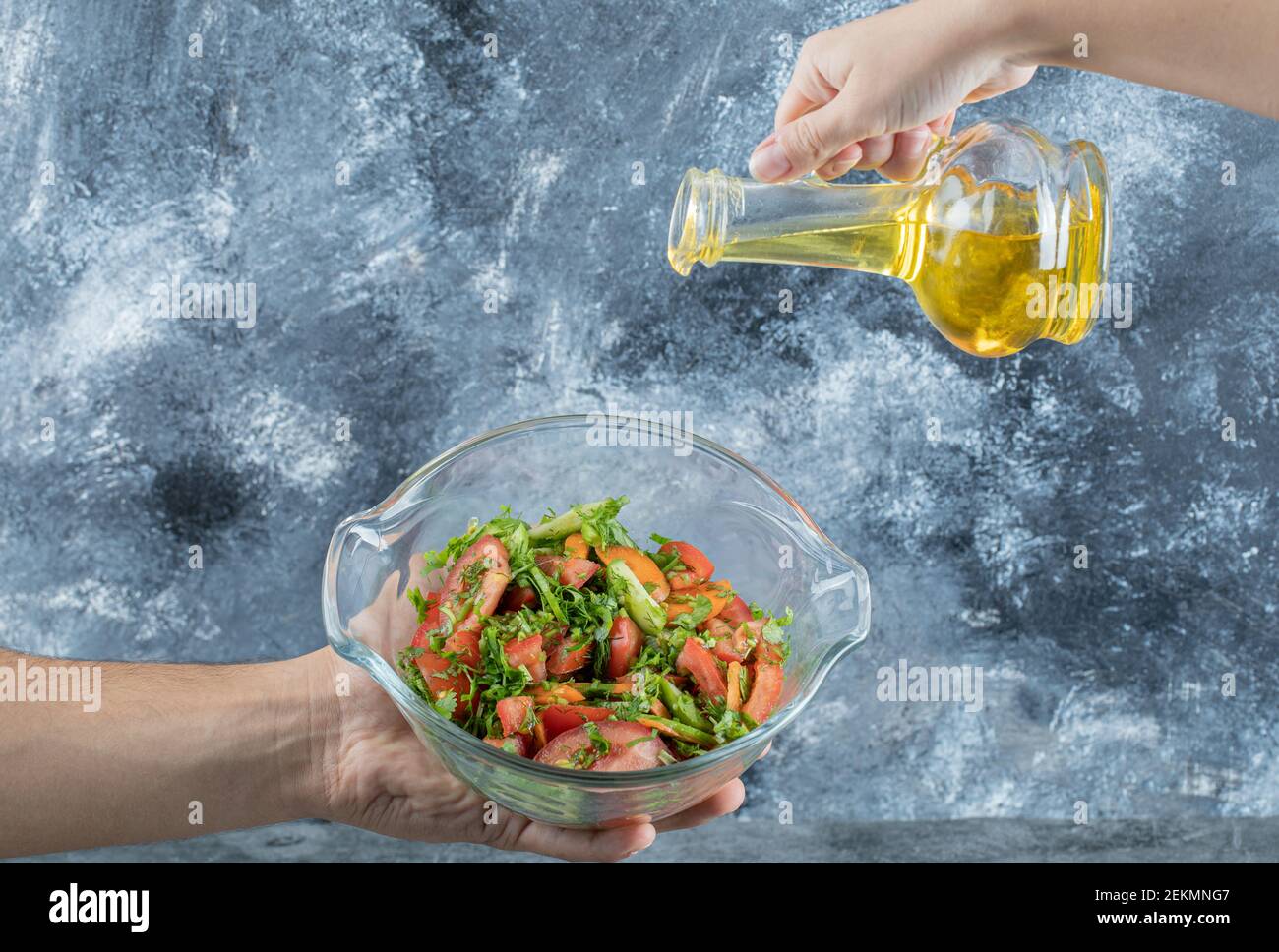 Hand pouring an oil in vegetable salad Stock Photo - Alamy