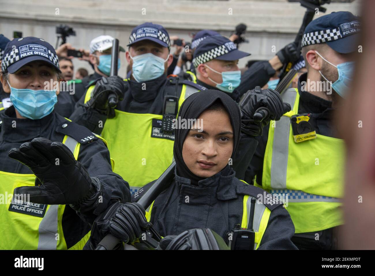 Police officer with out a face mask, holding a baton during the ...