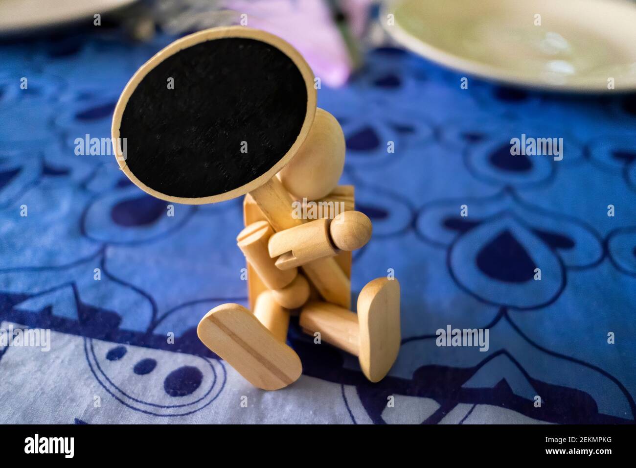 wooden dummy sitting on a restaurant table holding empty banner , black ...