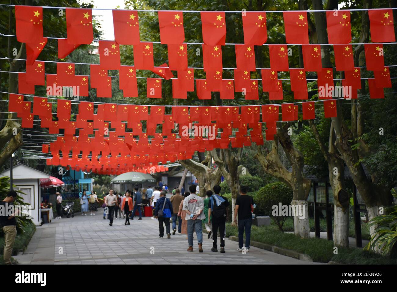 National flags fly on the street, under which vehicles and pedestrians ...
