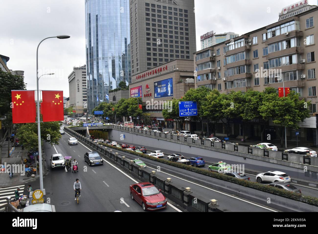 National flags fly on the street, under which vehicles and pedestrians ...