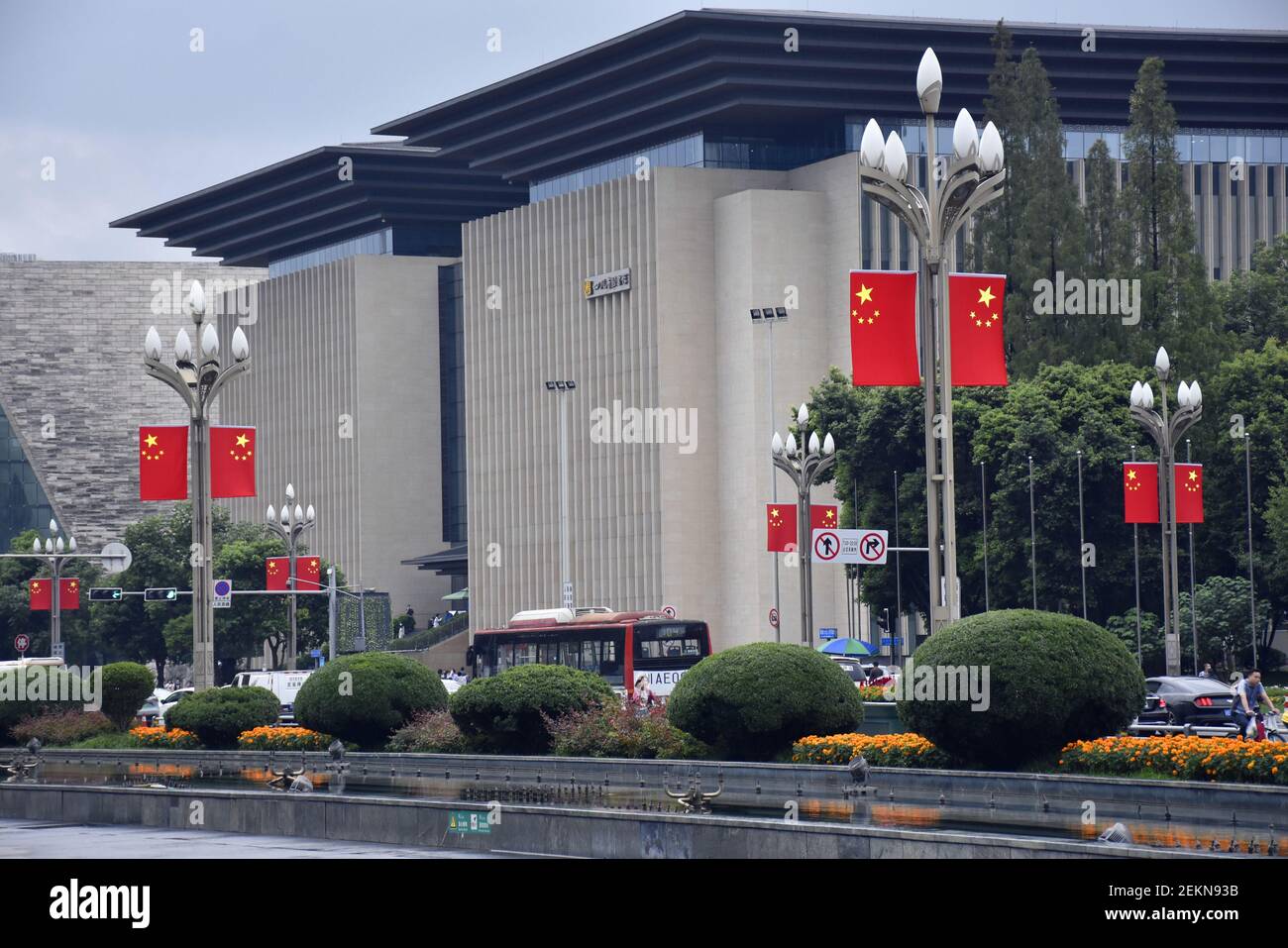 National flags fly on the street, under which vehicles and pedestrians ...