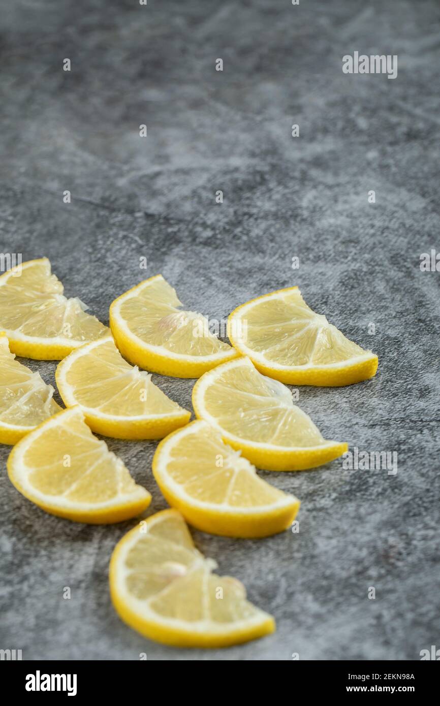 Slices of sour lemon on a gray background Stock Photo - Alamy