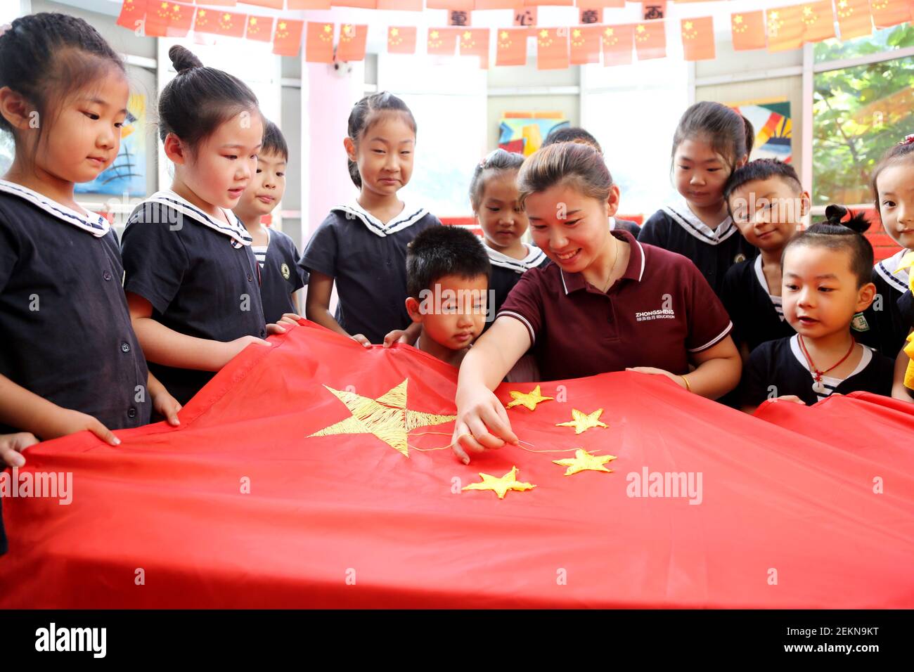 Kids hold a Chinese flag used in a class as patriotic education at the ...