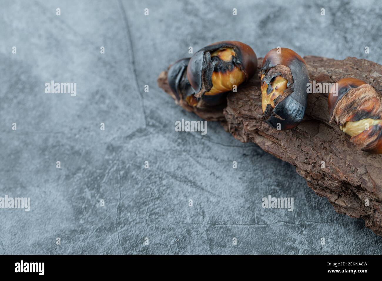 Delicious fried chestnuts on a tree bark Stock Photo - Alamy