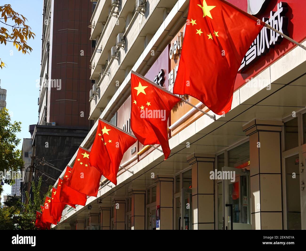 Chinese flags are set up on the buildings on a street in Urumchi city ...