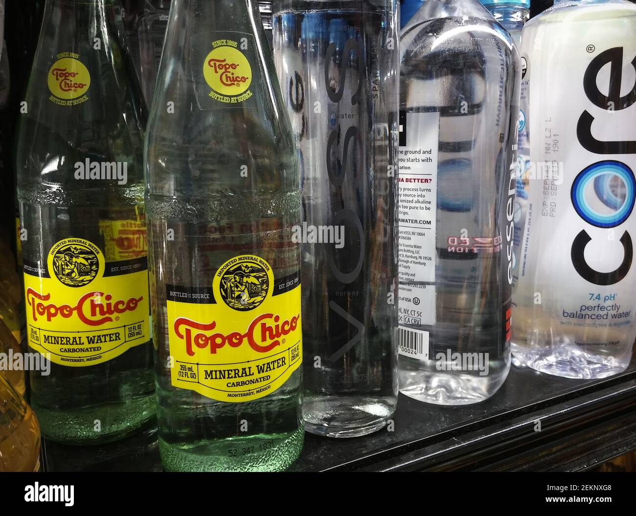Bottles of Coca-Cola owned Topo Chico Mexican bottled water with other branded water in a ...