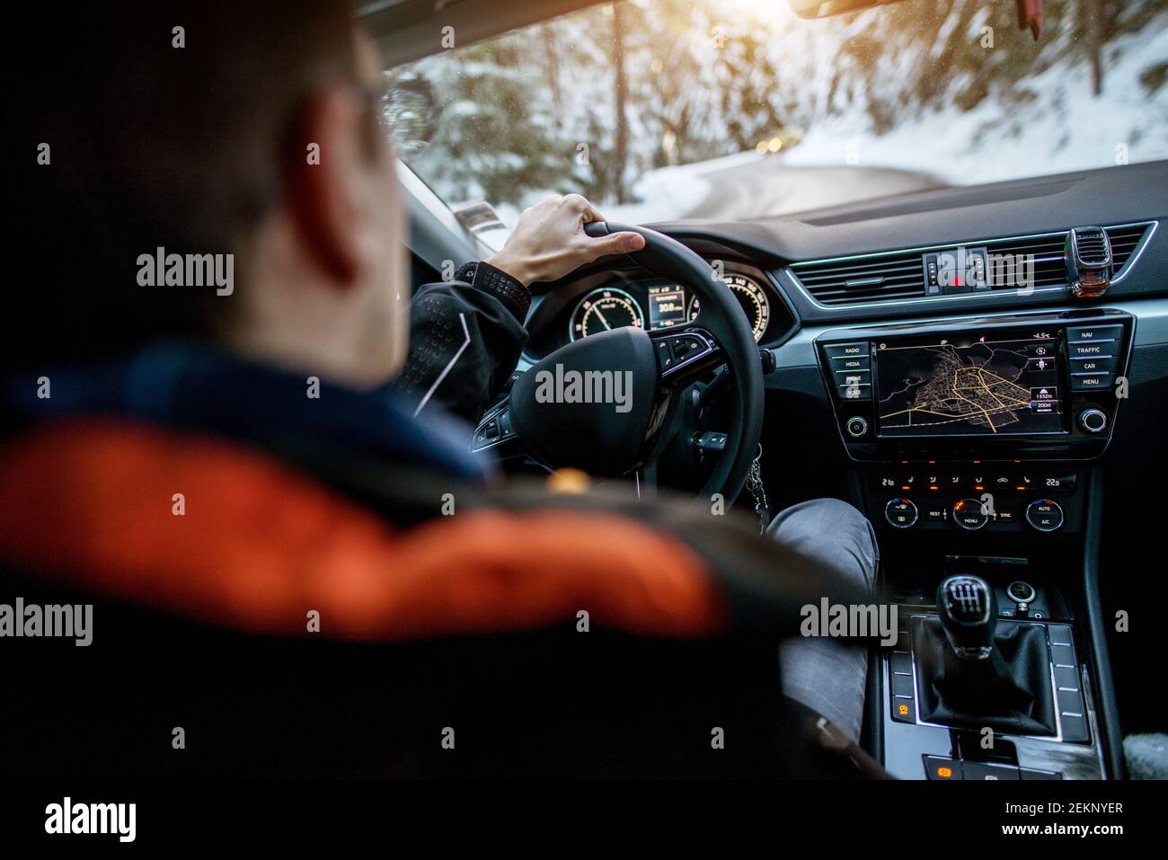 Rear view from the car of modern young man driving through snowy ...