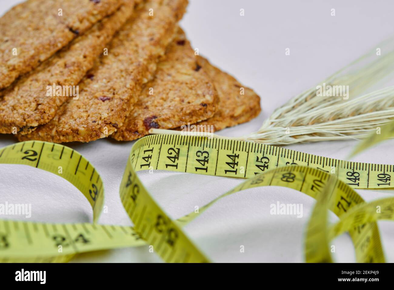 Biscuits and tape measure on a white background Stock Photo - Alamy