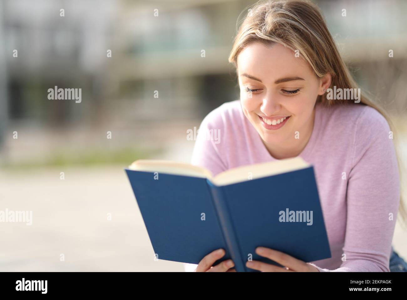 Teen girl smiling reading book hi-res stock photography and images - Alamy