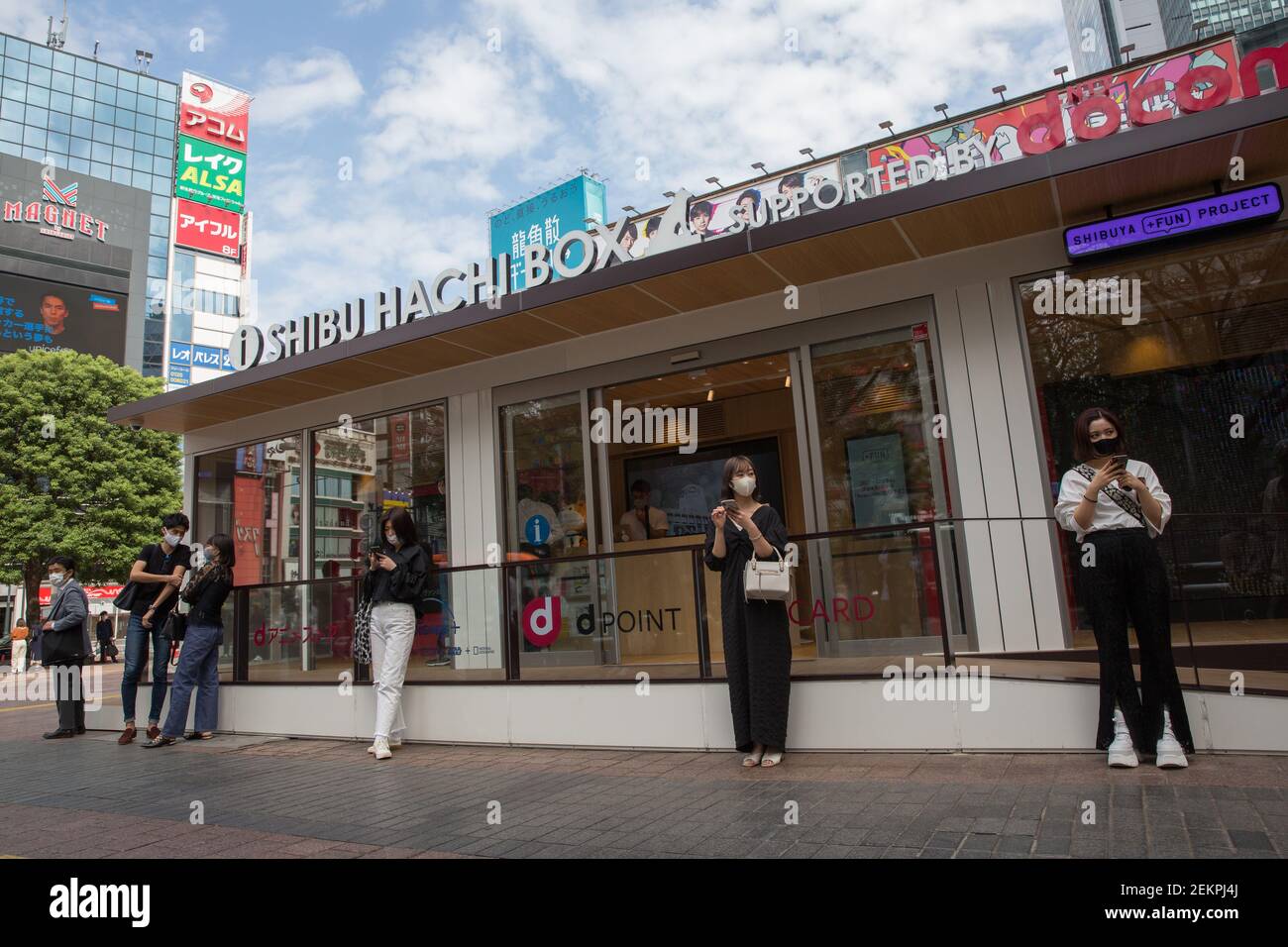 People wearing face masks stand in front of Shibuya’s new tourist information centre ‘Shibu ...