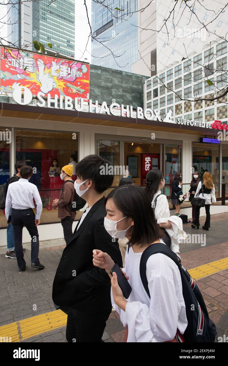 People wearing face masks walk past a newly opened tourist information ...
