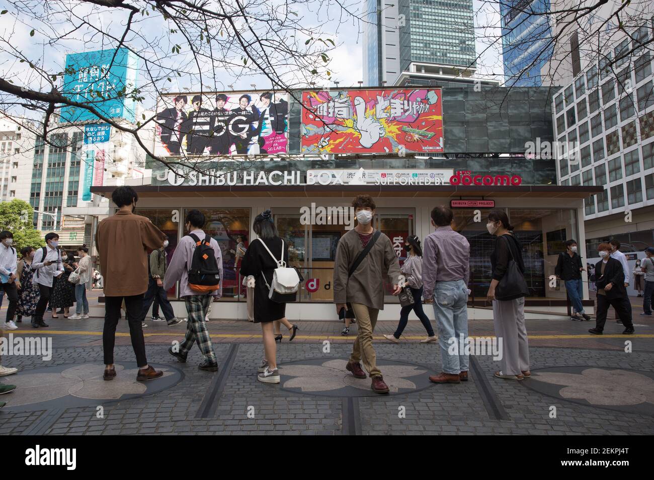People wearing face masks walk past a newly opened tourist information ...
