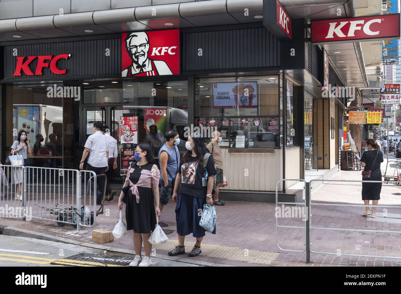 Pedestrians wearing masks are seen in front of the American fast food ...