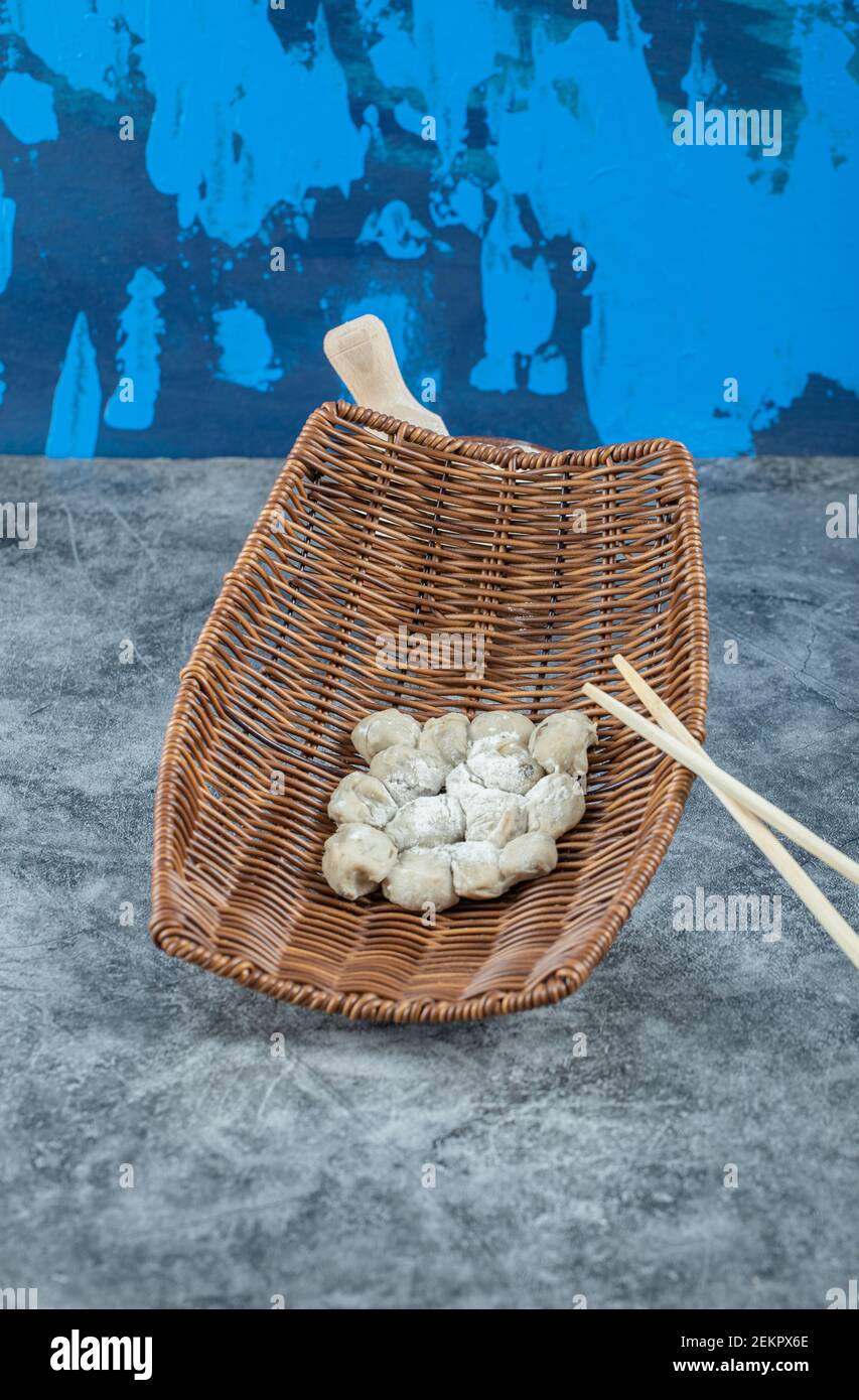 A wicker basket of raw dumplings and chopsticks Stock Photo - Alamy