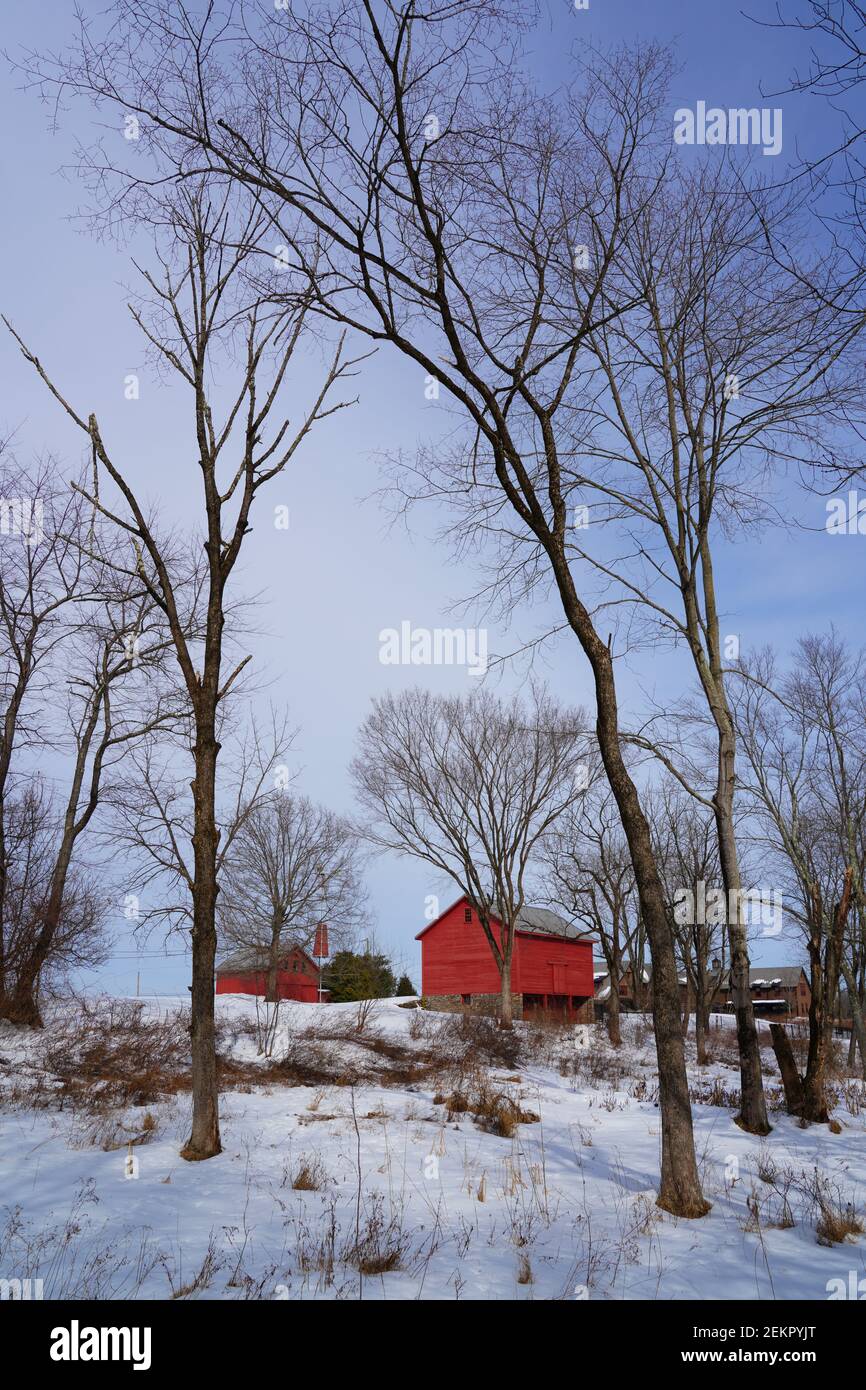 View of a traditional red barn under snow after a winter storm in New ...
