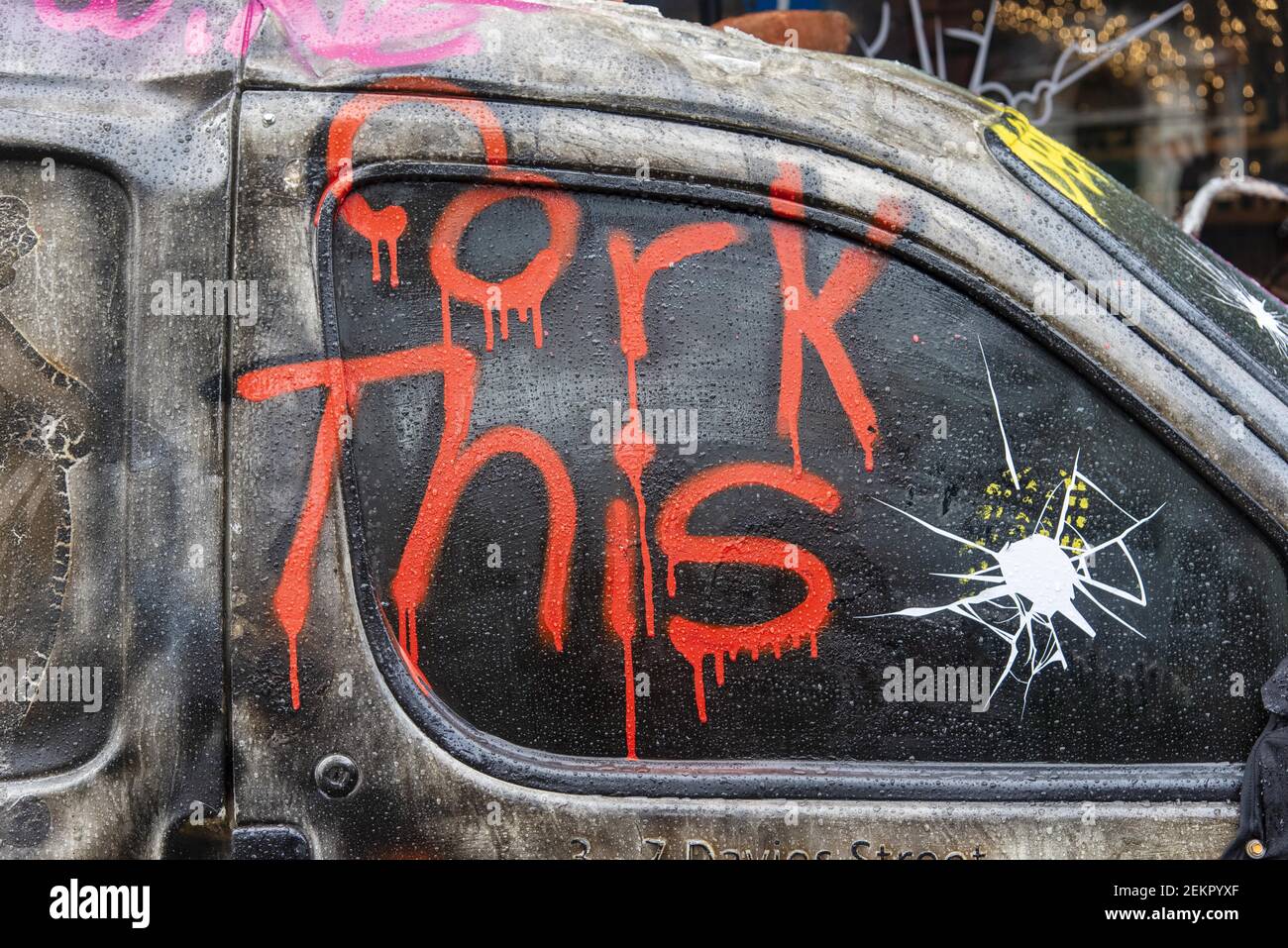 An art installation of a wrecked car with graffiti on it by Hedonism ...