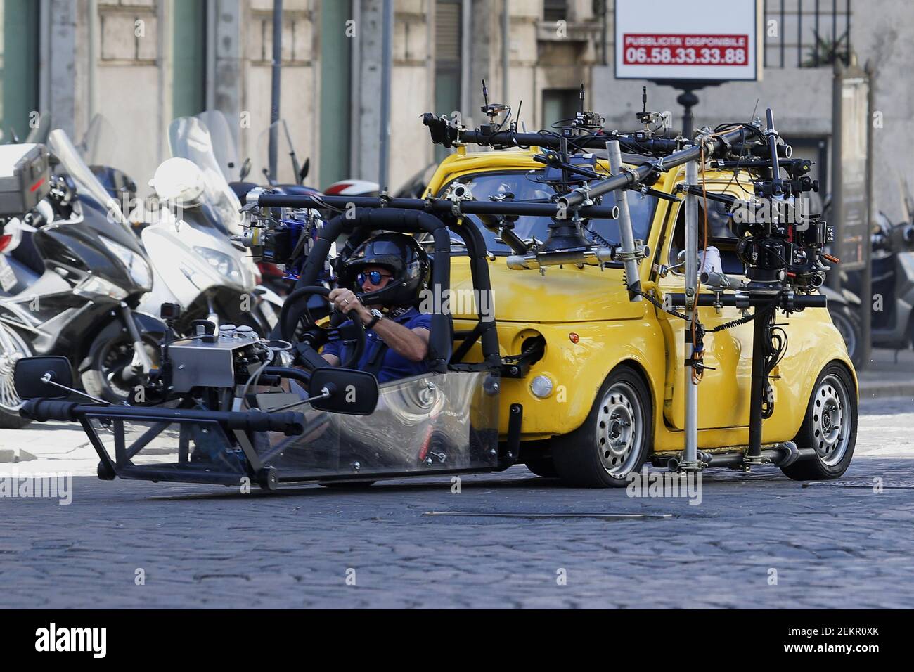 Actor Tom Cruise and actress Hayley Atwell in a yellow Fiat 500 driven ...
