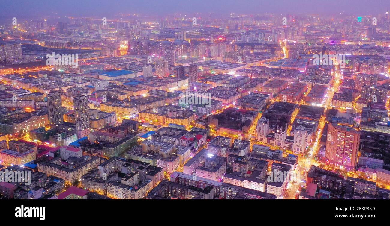 An aerial view of the whole urban area lighting up as night arrives and ...