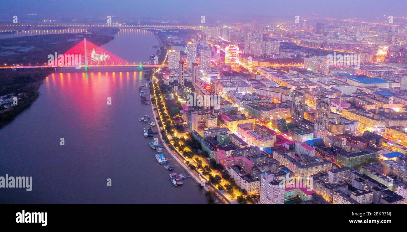 An aerial view of the whole urban area lighting up as night arrives and ...