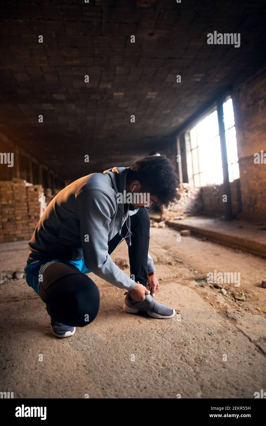 Close up view of sporty active afro american runner man crouching and ...