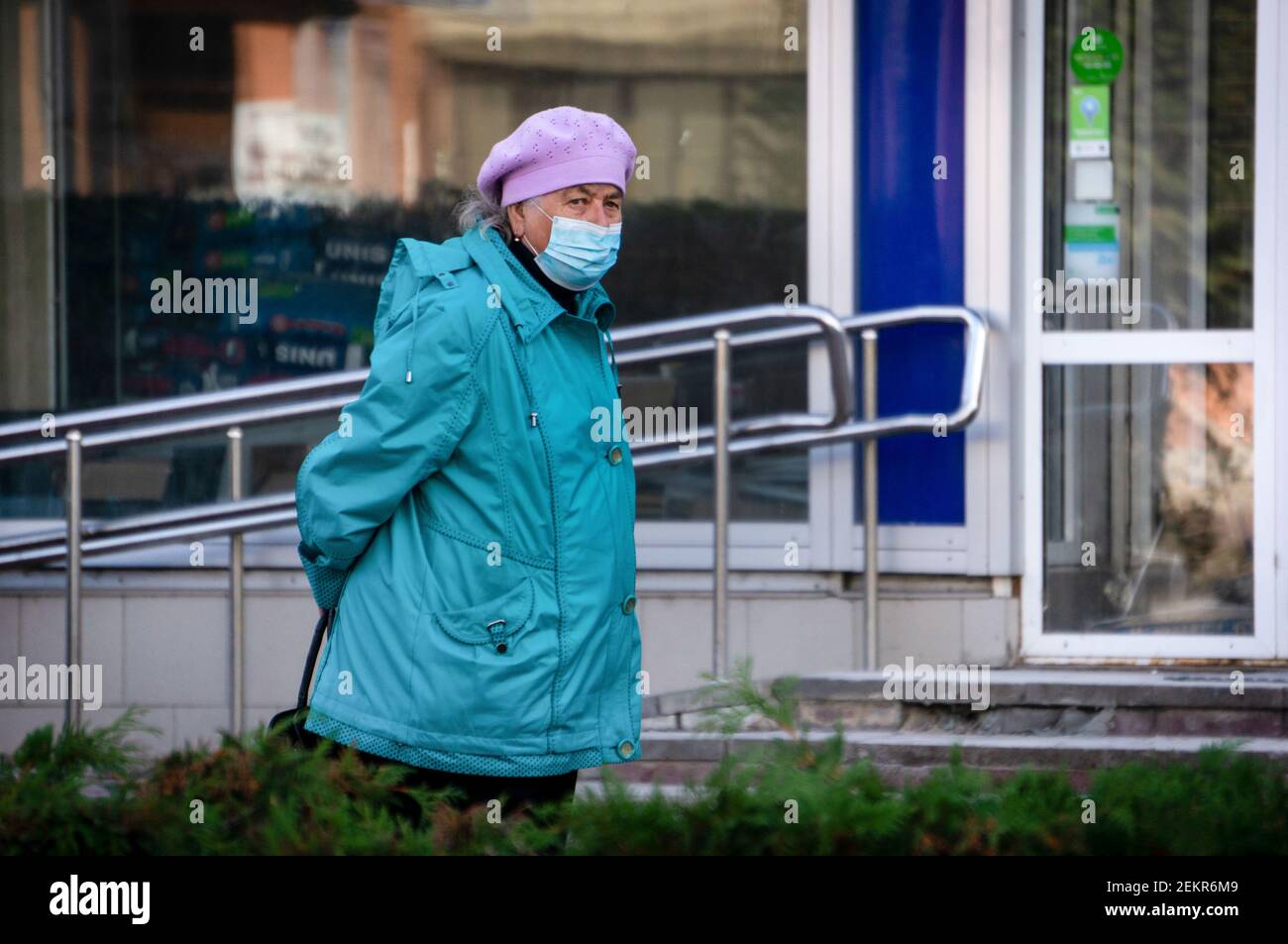 Russian pensioner wearing a face mask walks along the International ...