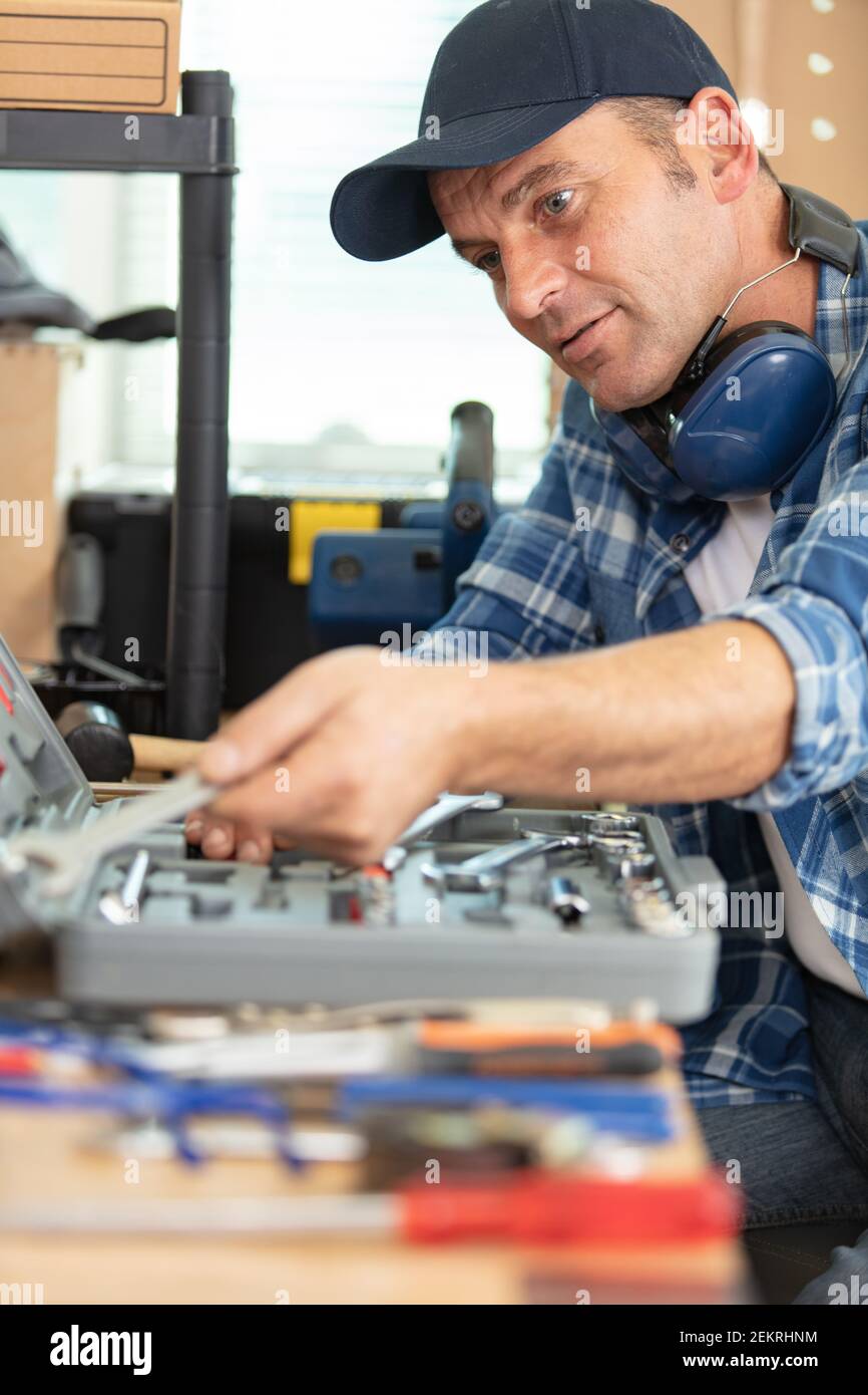 happy repairmanlooking for tools in toolbox Stock Photo - Alamy