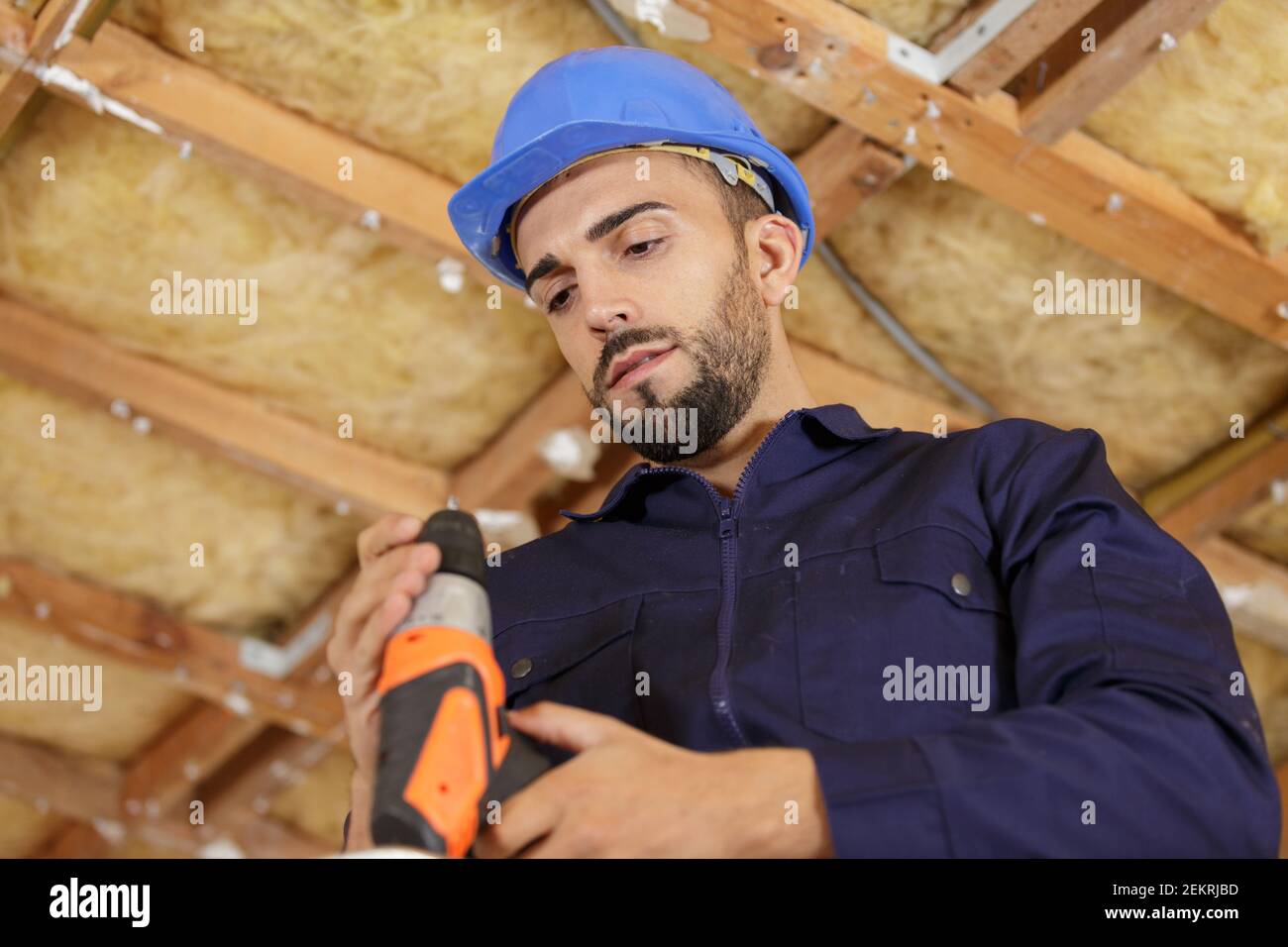 man builde examining a drill Stock Photo - Alamy