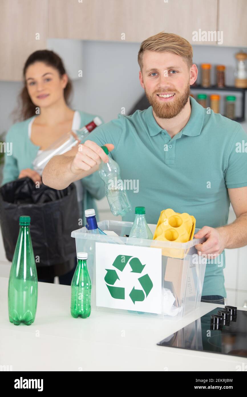 a young couple recycling plastic in their kitchen Stock Photo - Alamy