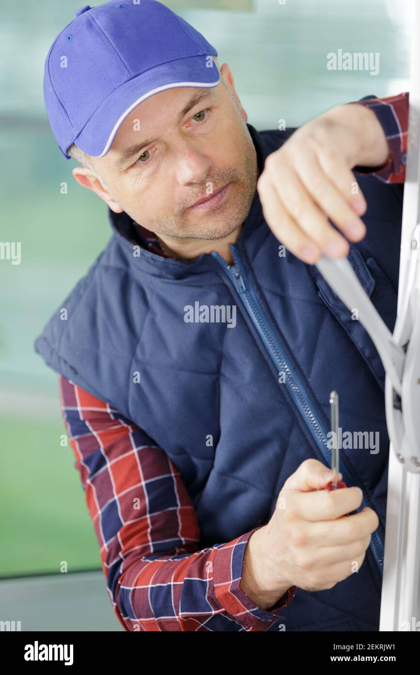 Maintenance worker fixing a window hi-res stock photography and images ...