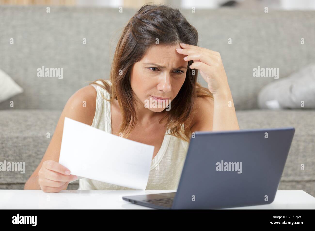 worried woman reading a letter at home Stock Photo - Alamy