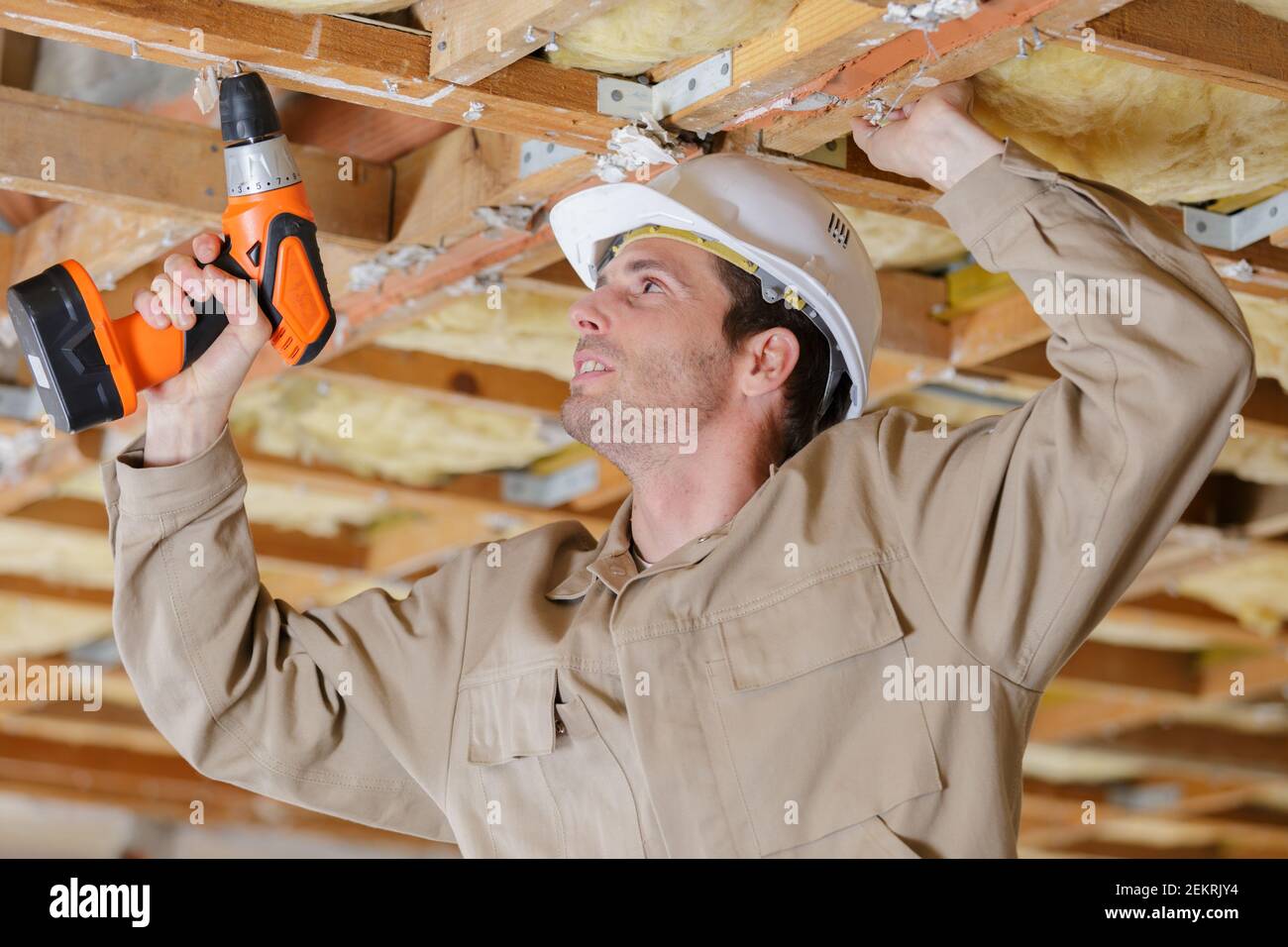 worker is using a drill in the ceiling Stock Photo - Alamy