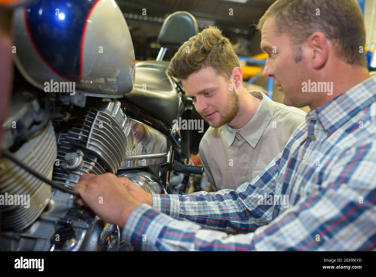 two men checking a motorbike Stock Photo - Alamy