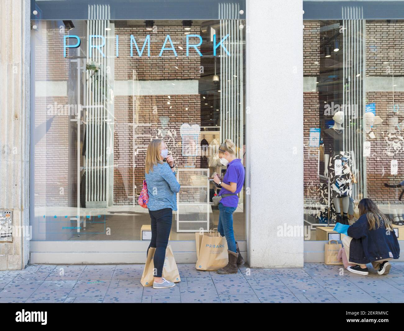 Women with shopping bags are seen in front of the Primark store. (Photo ...