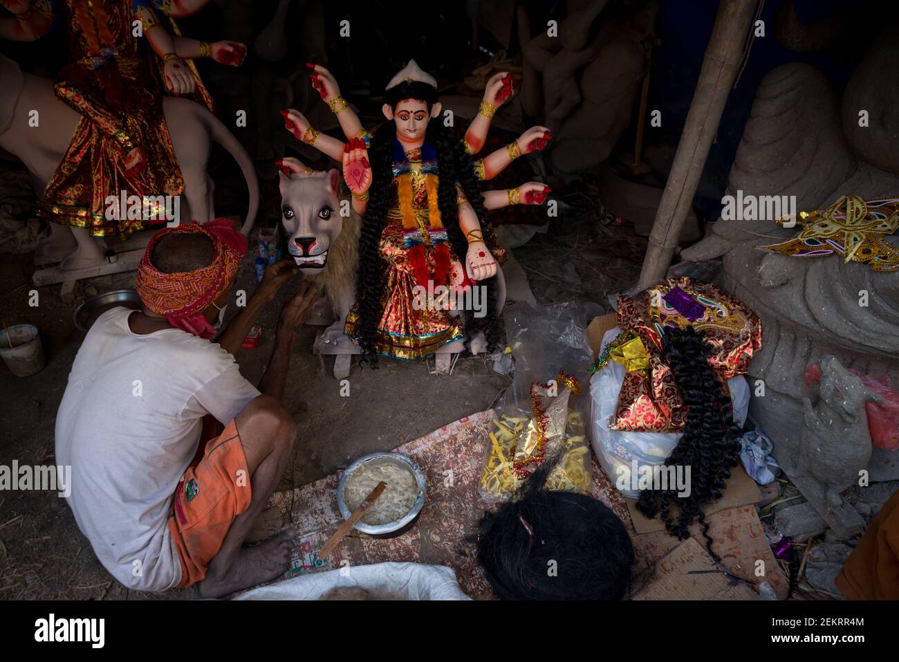 An artist gives a final touch to a statue of Hindu goddess Durga ahead ...