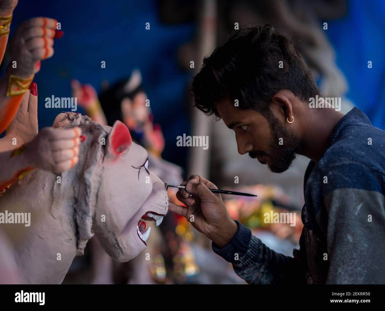 An artist gives a final touch to a statue of Hindu goddess Durga ahead ...