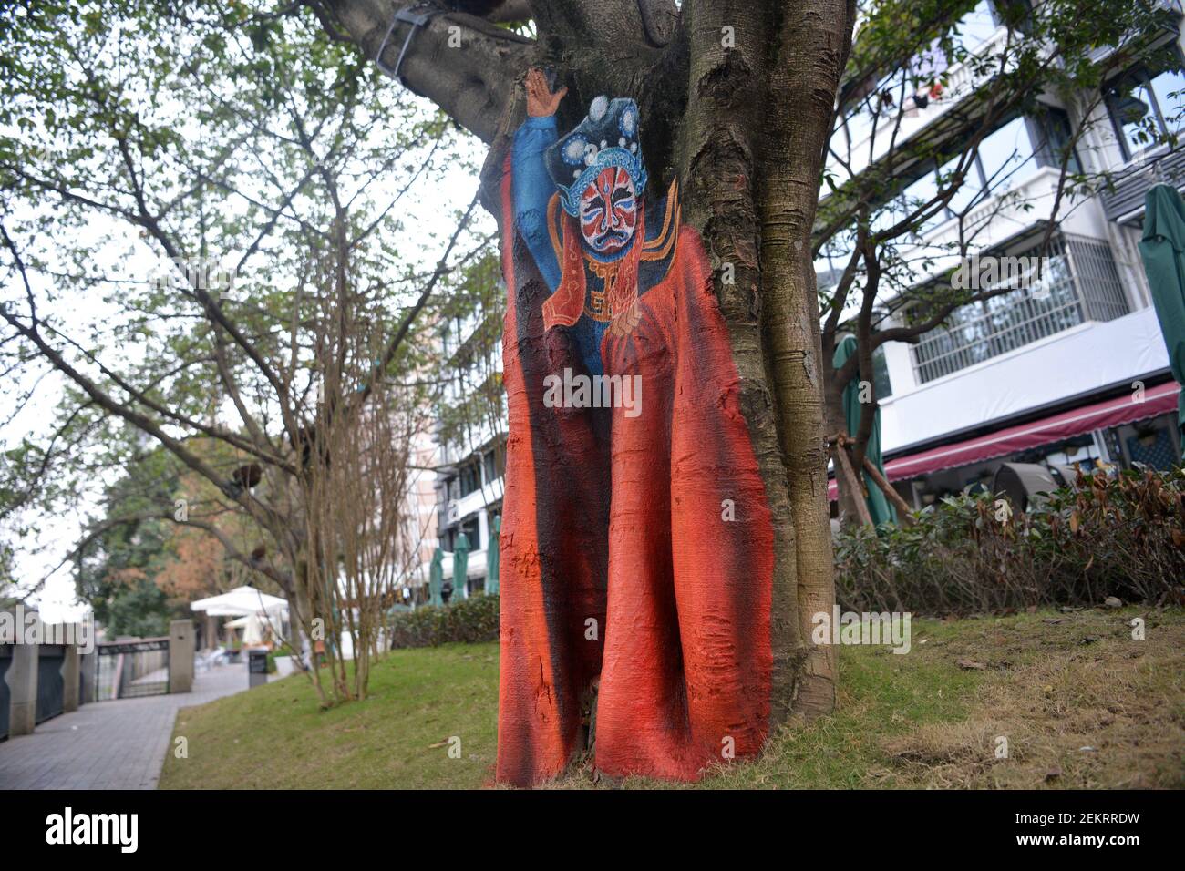 More than ten trees on a street are painted with graffiti, showing the ...