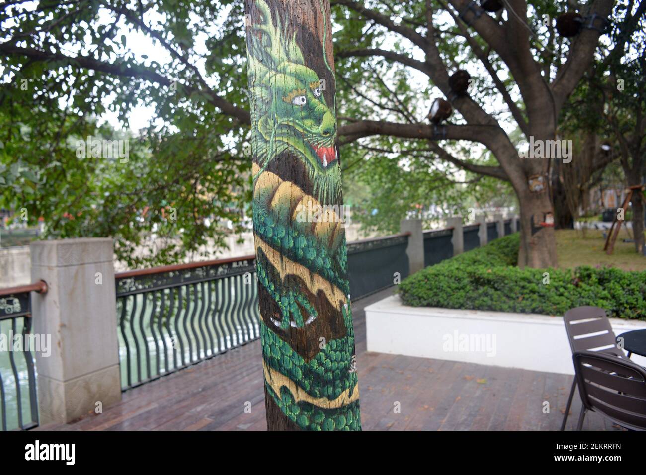 More than ten trees on a street are painted with graffiti, showing the ...