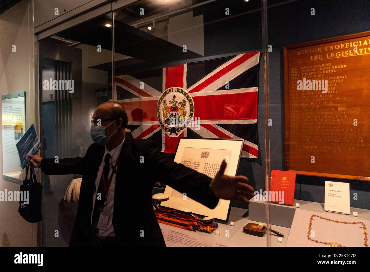 A security guard wearing a face mask standing close to a colonial Hong ...